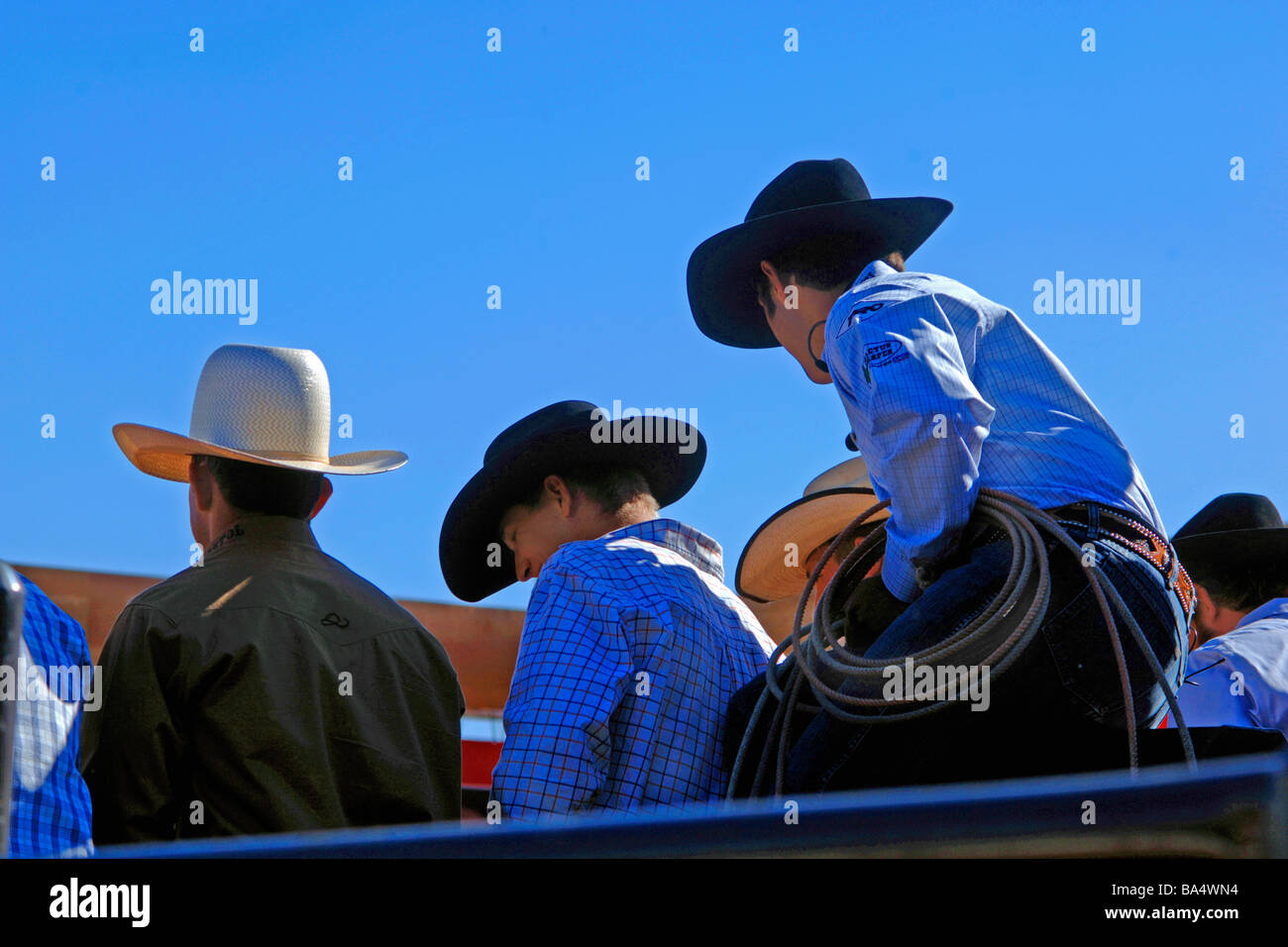 Cowboys resting on a rail fence between between bull rider events at ...