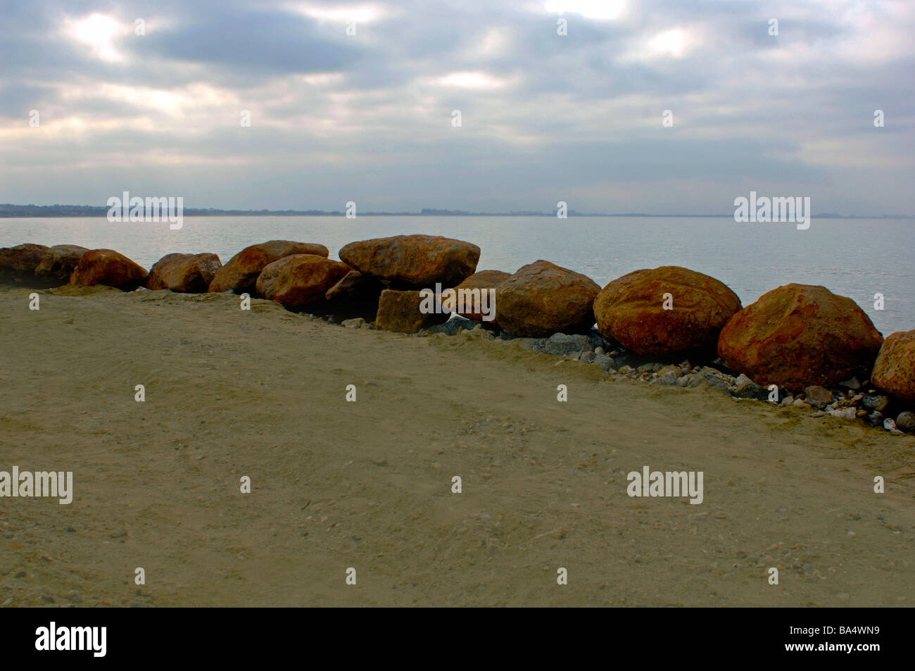 Rocks on a jetty with a tropical sea and low clouds in the background ...