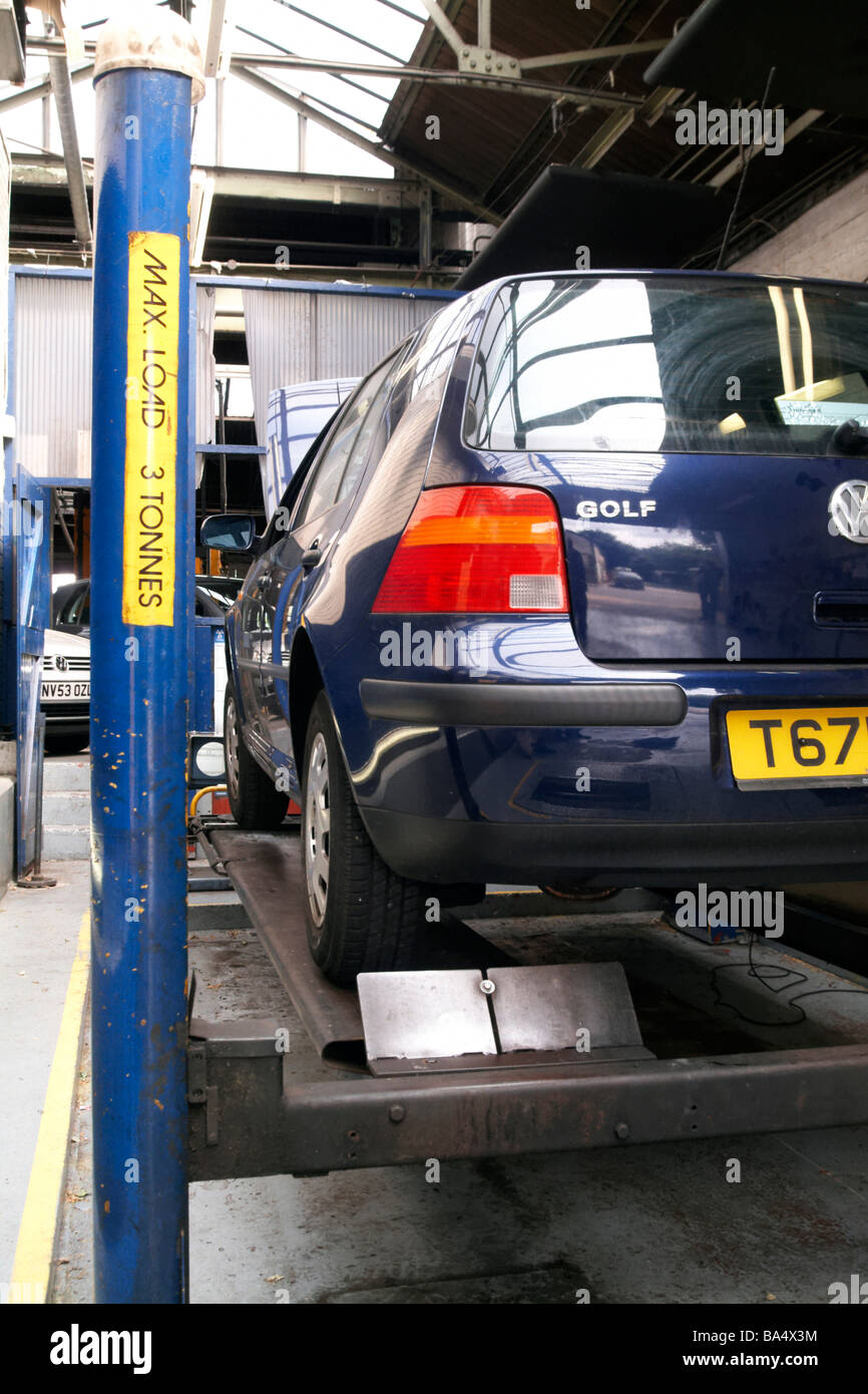 car on a ramp in a garage being repaired Stock Photo - Alamy