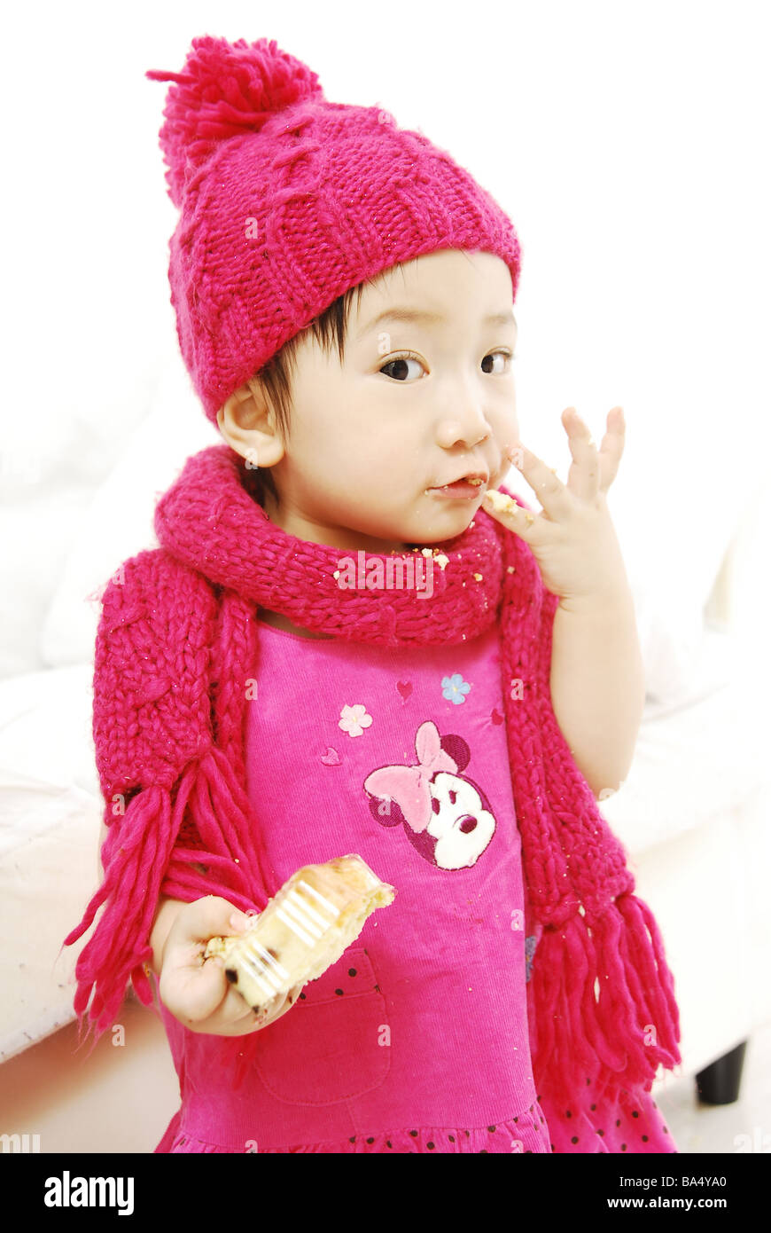 Cute Chinese baby girl eating a biscuit Stock Photo - Alamy