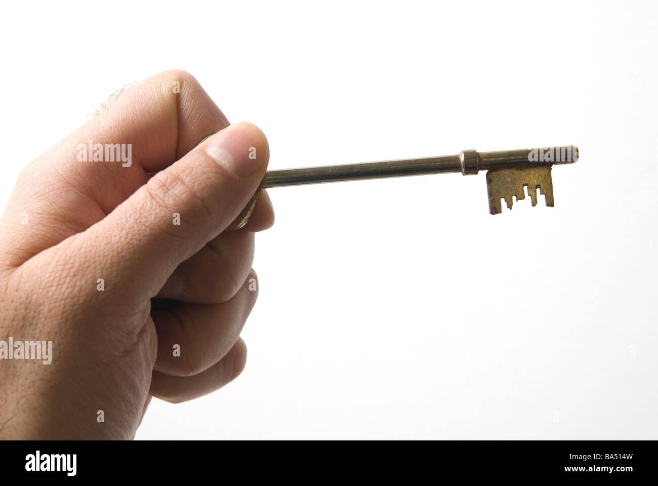 Hand holding an old fashioned key against a white background Stock ...