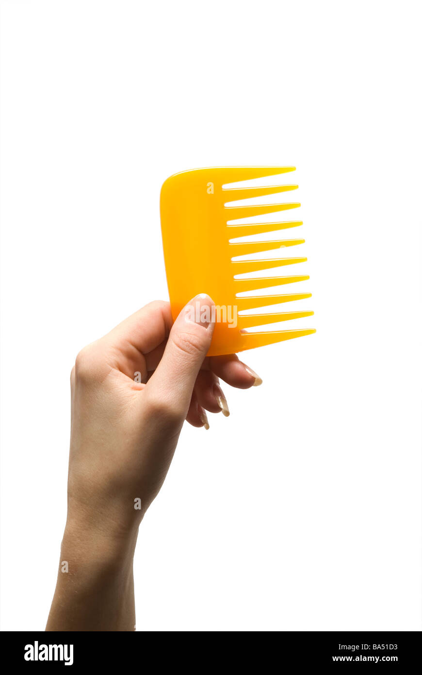Hand holding a plastic yellow comb against a white background Stock ...