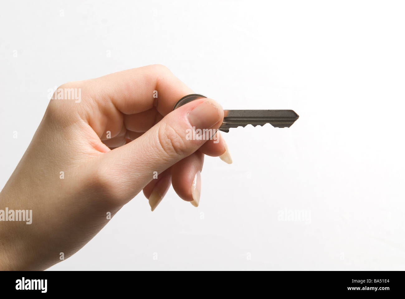 Hand holding a house key against a white background Stock Photo - Alamy