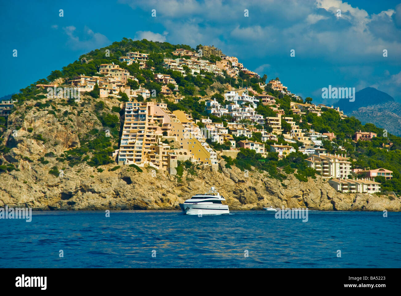 Houses on cliff and yacht at entrance to Port Andratx Majorca Baleares ...