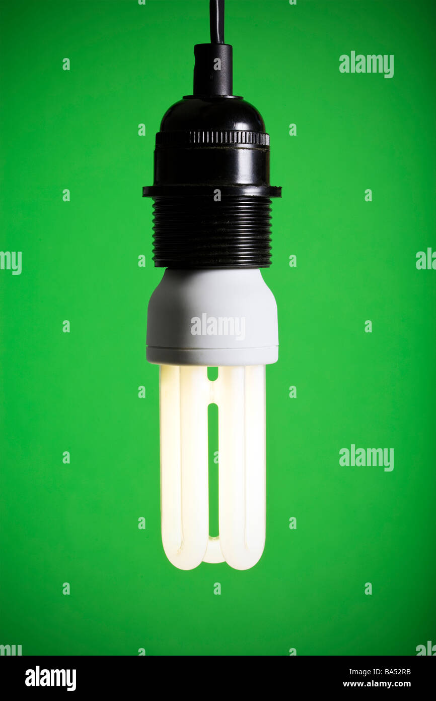 compact fluorescent lightbulb in socket, green background Stock Photo ...