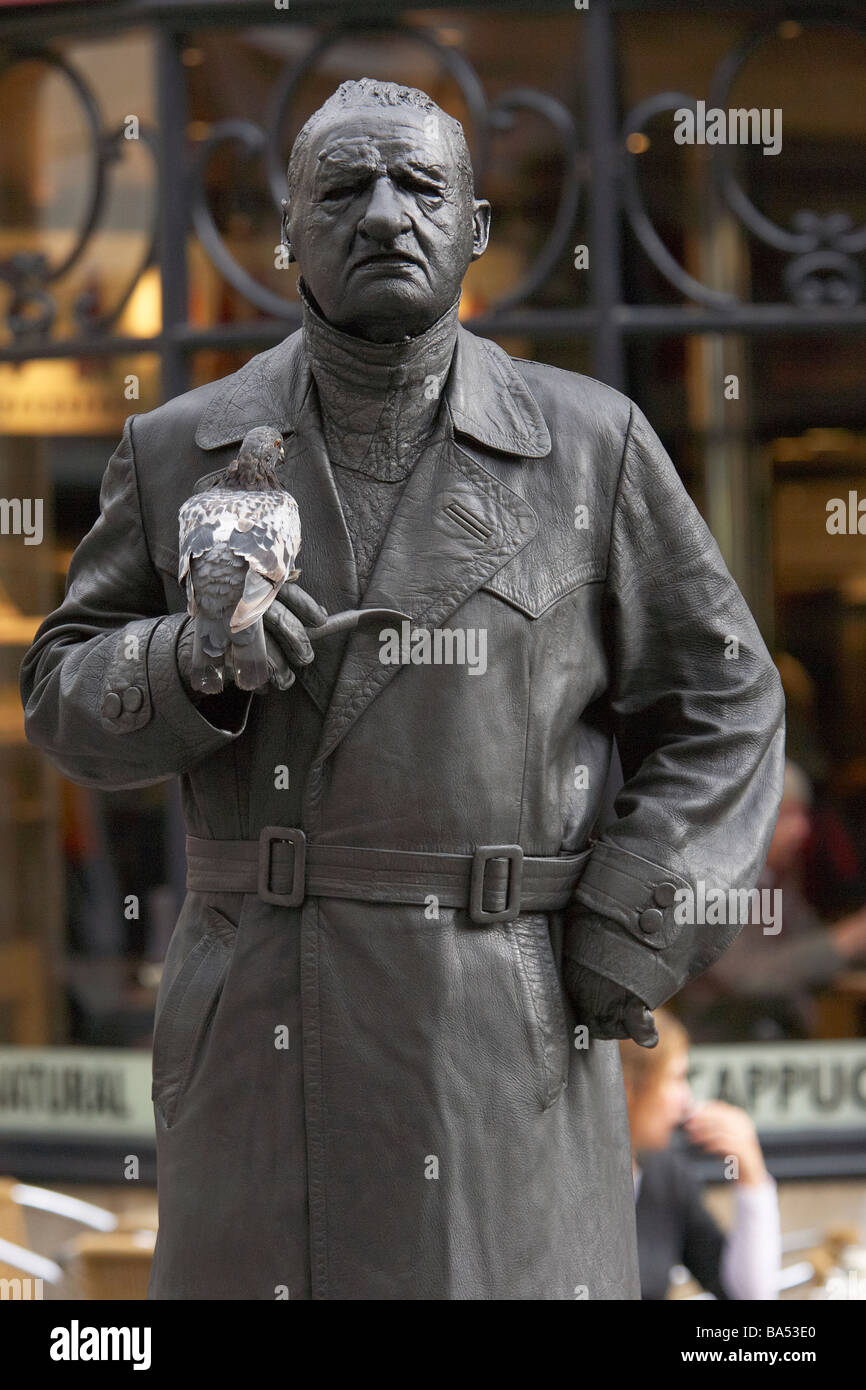 A street performer dressed up as human statue stands in a street in ...