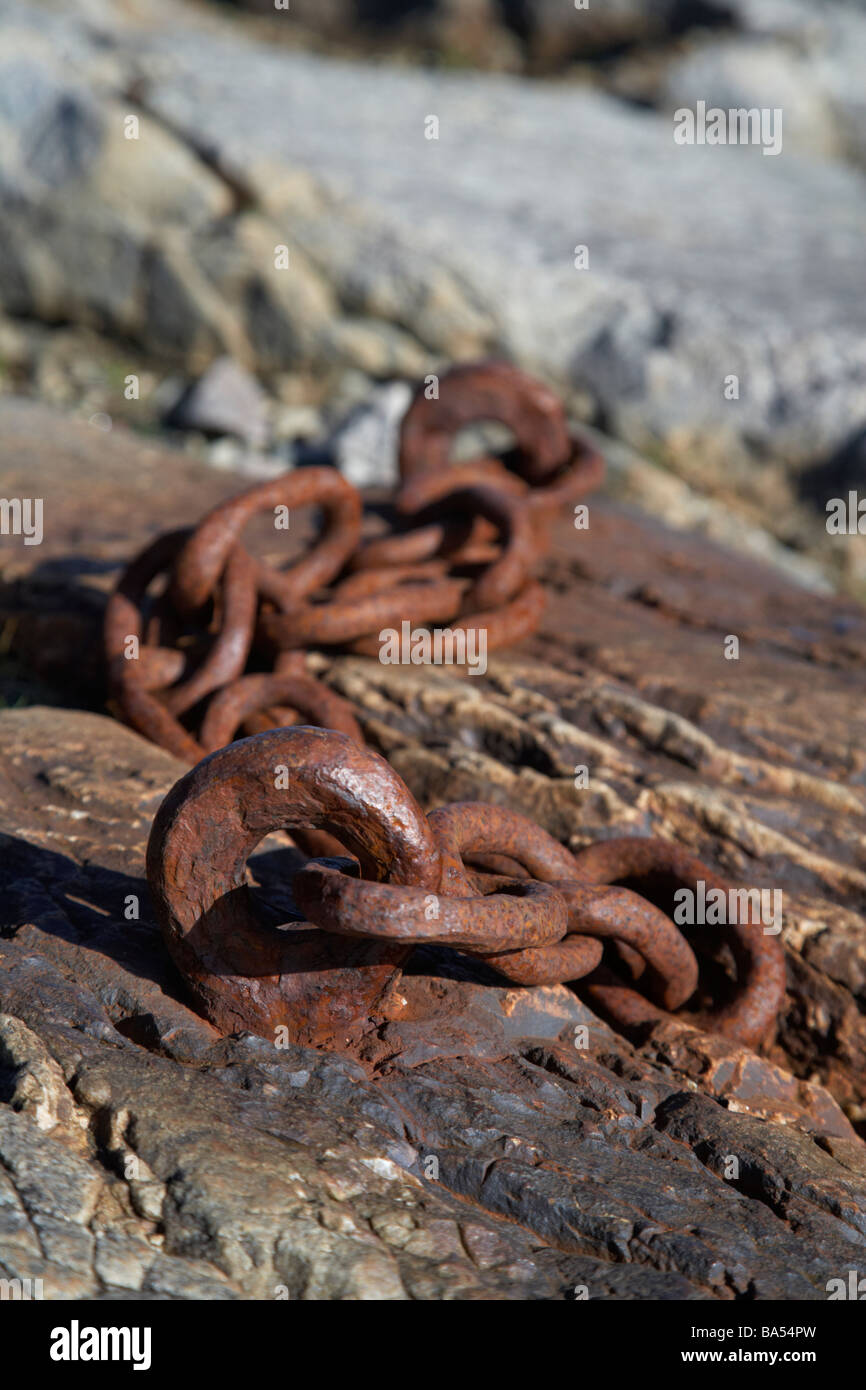 old rusty chain anchored to a rock weathered by rain Stock Photo - Alamy
