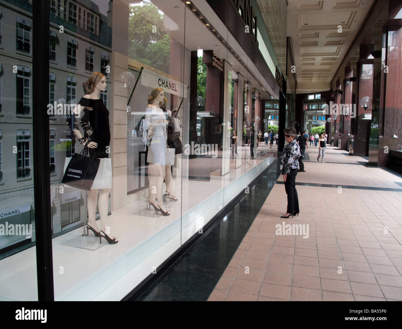 A woman looks in the window of a luxury goods store in Singapore Stock ...