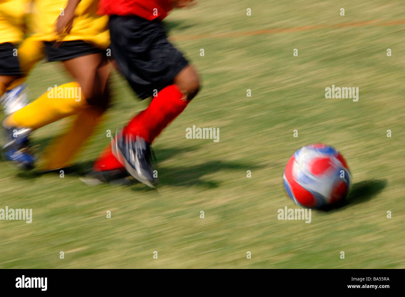 Youths on a soccer field, racing for the ball Stock Photo - Alamy