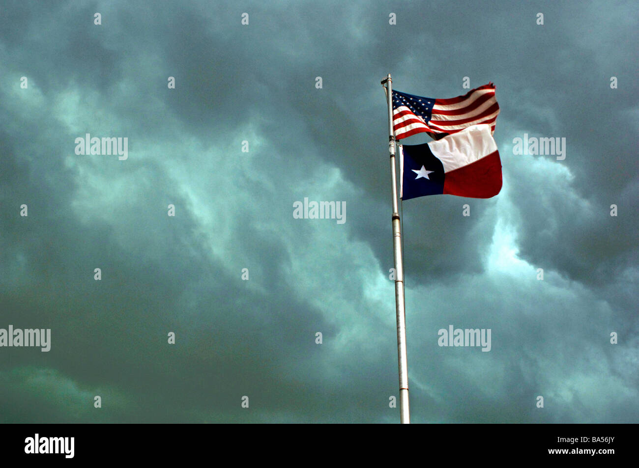 Dramatic dark storm clouds gather over a flag pole with the US and ...