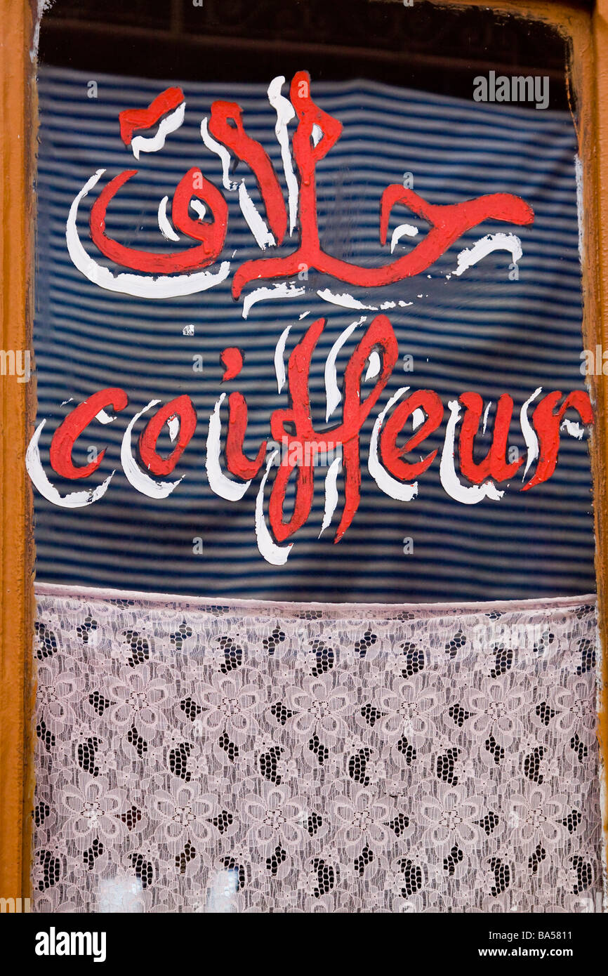 Hand painted sign for a barbers hairdressers shop written in both ...