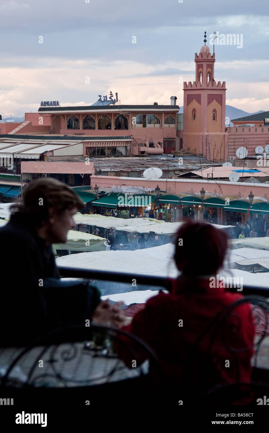 Tourists relax drinking mint tea from a cafe roof terrace overlooking ...