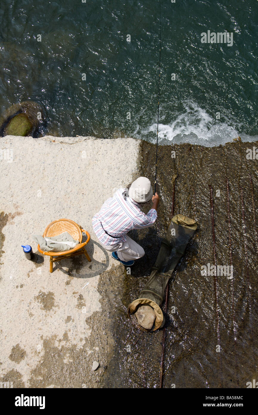 Fisherman at weir edge, low head dam, aerial view of man fishing next ...