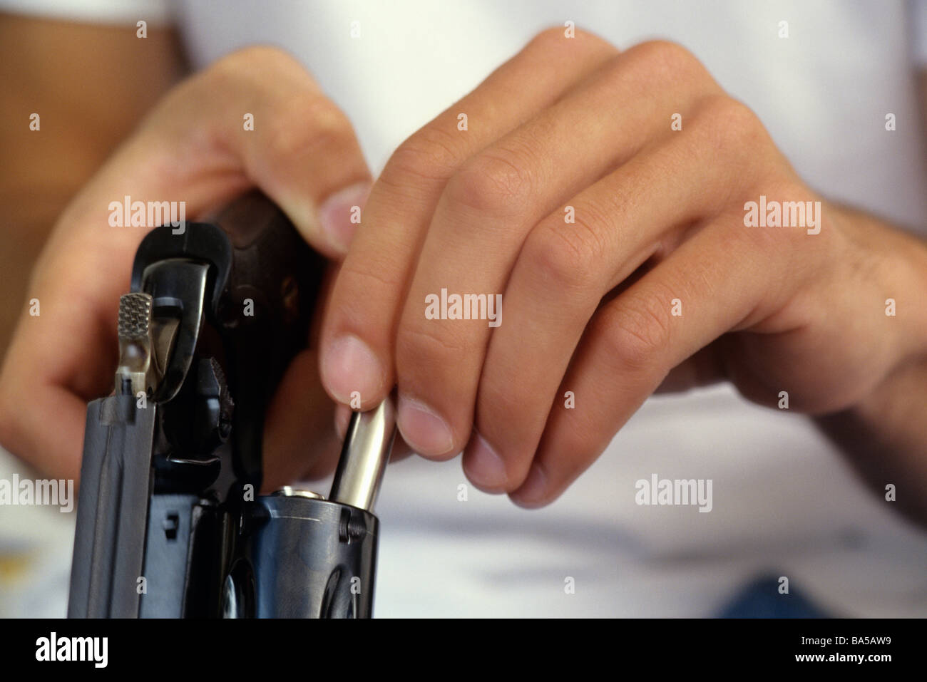 Teenager holding a handgun and loading gun with bullets MR Stock Photo ...