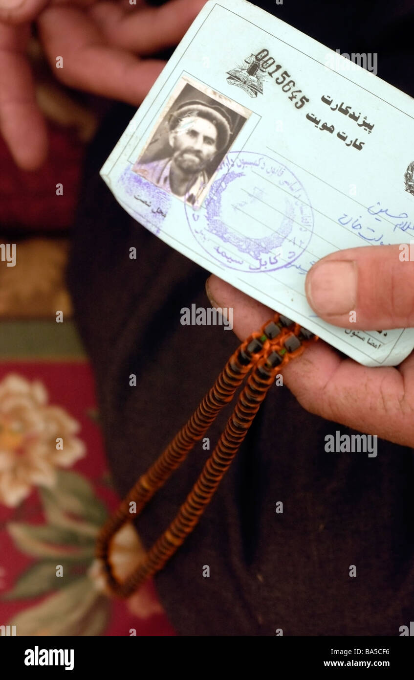 An Afghan man shows his identity card as he attends a Loya Jirga or ...