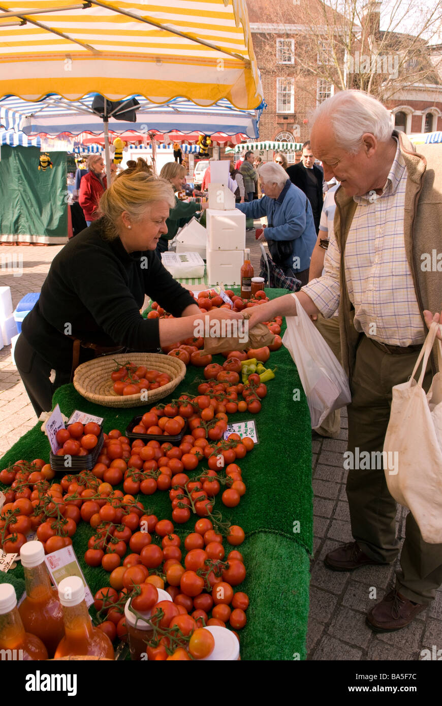 Tomato stall vendor serving customer at Petersfield Market, Hampshire ...