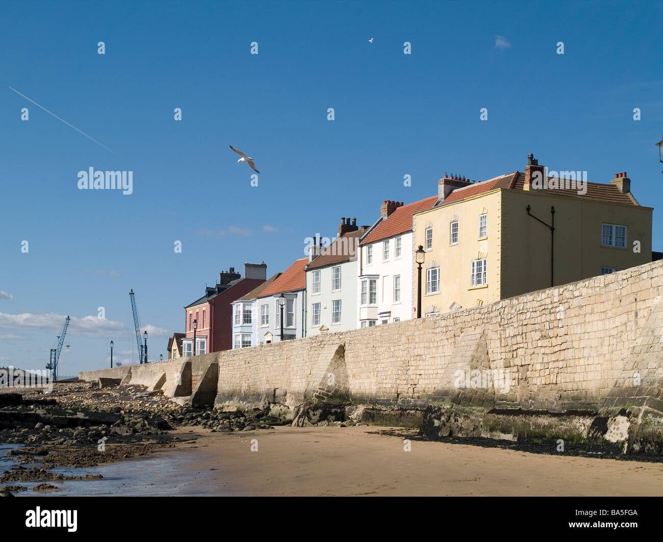 Houses protected by a sea wall originally built in medieval times at ...