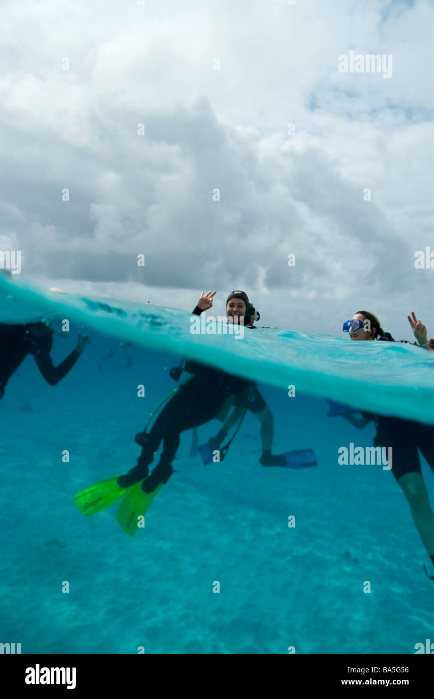 group of scuba divers floating at surface of clear blue caribbean water ...