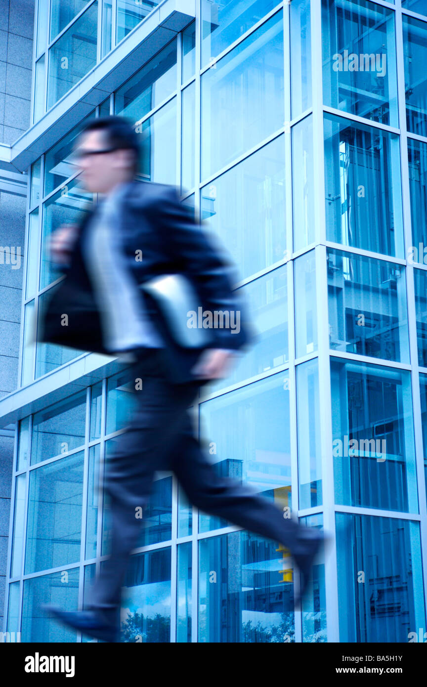 Businessman running with laptop in hand Stock Photo - Alamy
