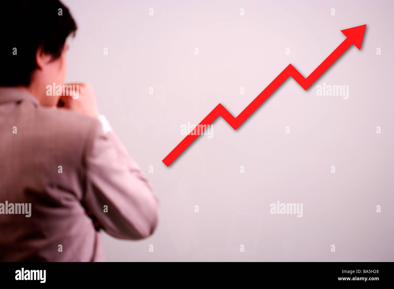Man watching chart on wall rear view Stock Photo - Alamy