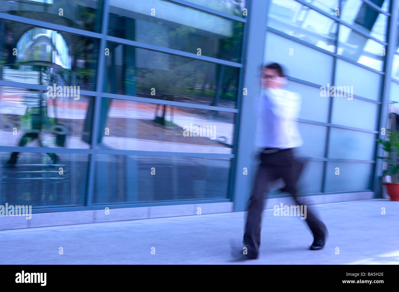 Businessman running in front of a building Stock Photo - Alamy