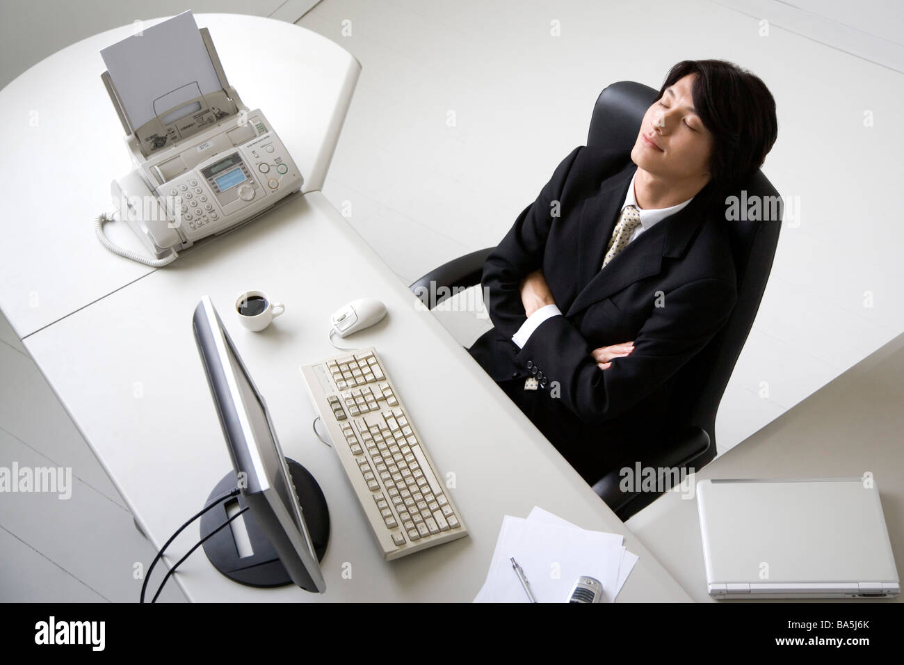 Asian businessman meditating sitting desk hi-res stock photography and ...