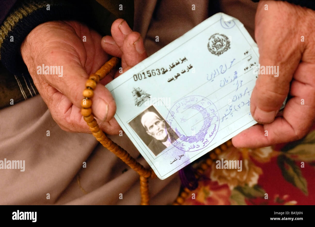 An Afghan man shows his identity card as he attends a Loya Jirga or ...