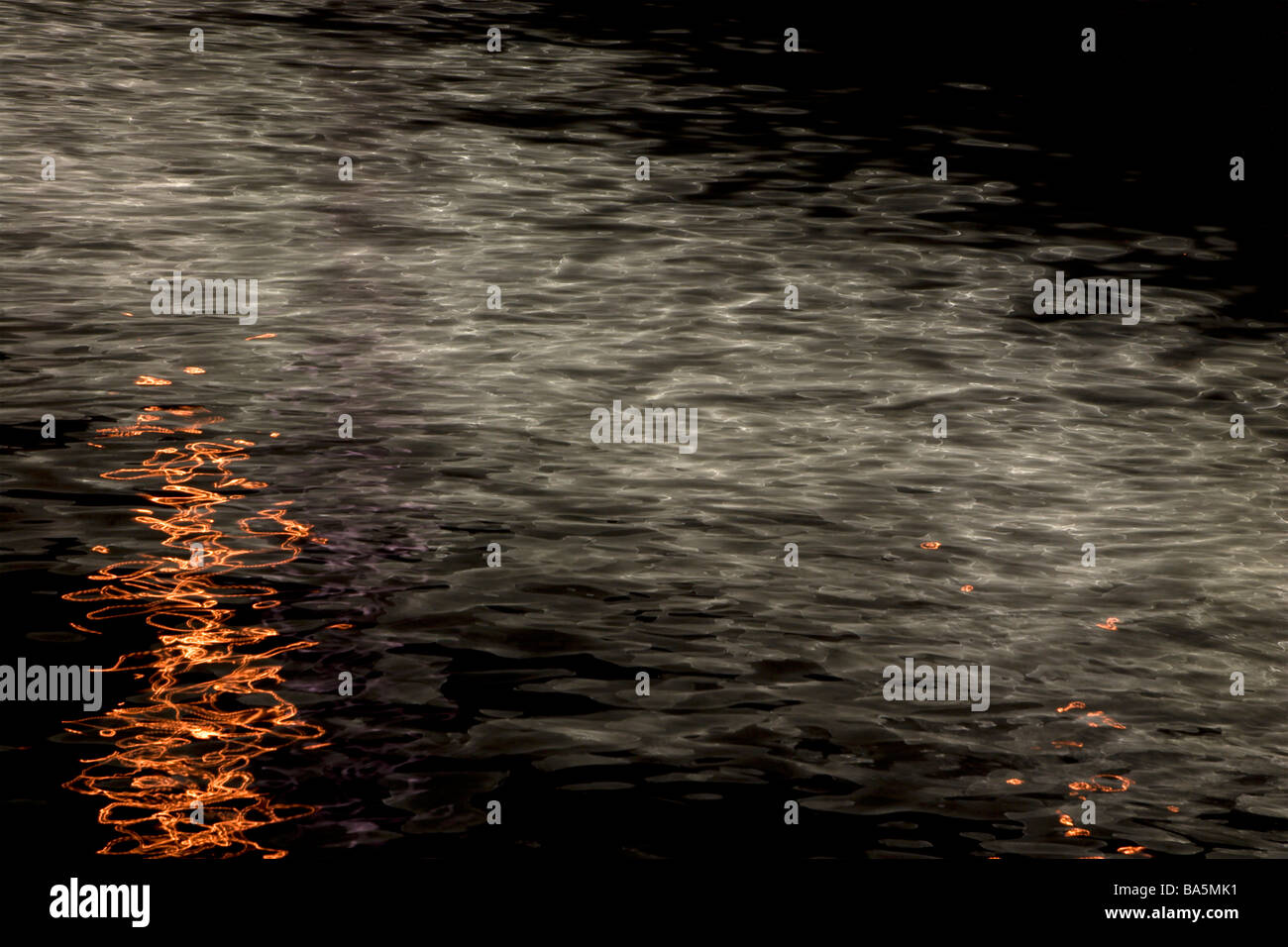 Moonlight and street lights reflections in river water at night Stock ...