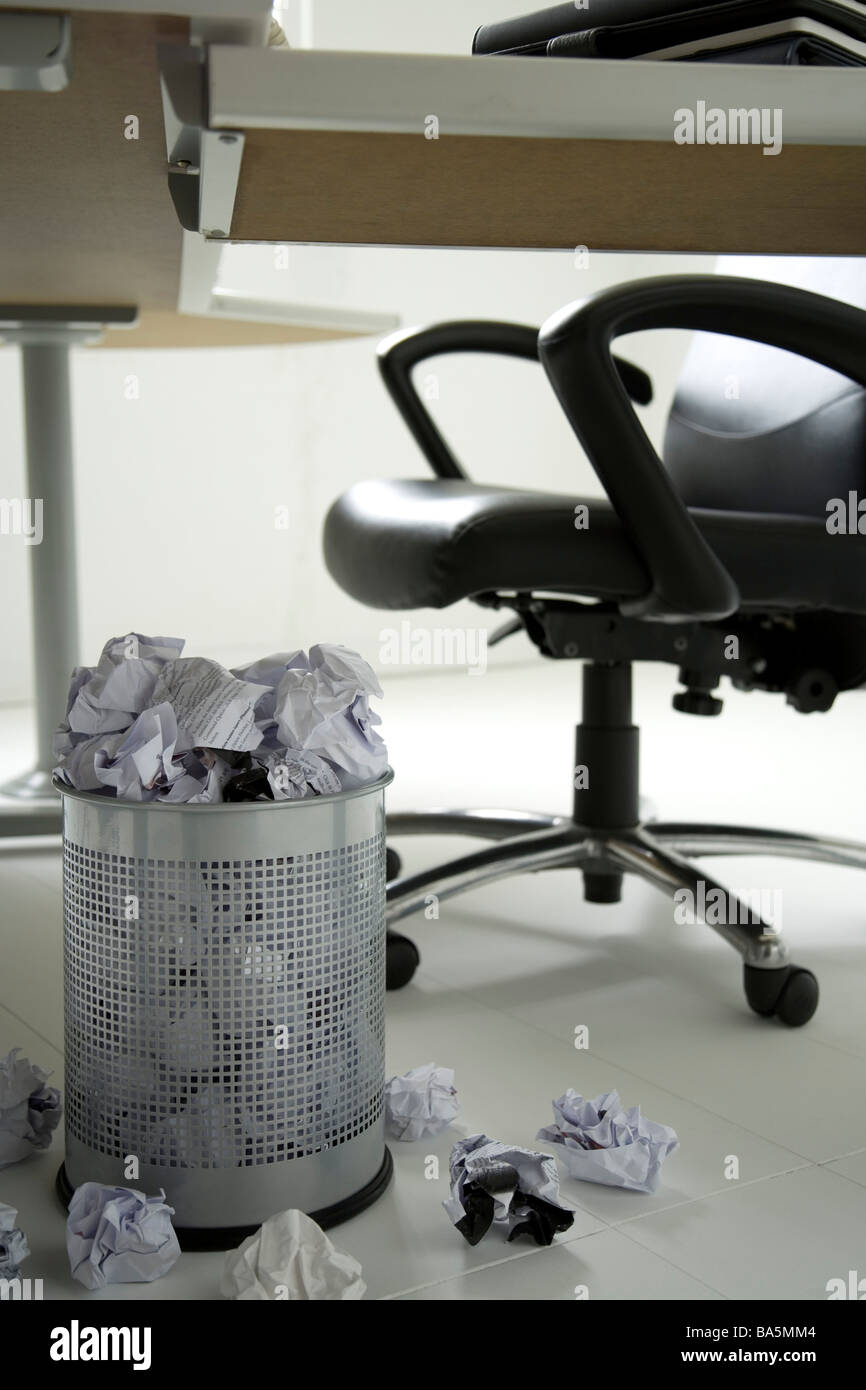 Crumpled paper falling into wastepaper basket under office desk Stock ...