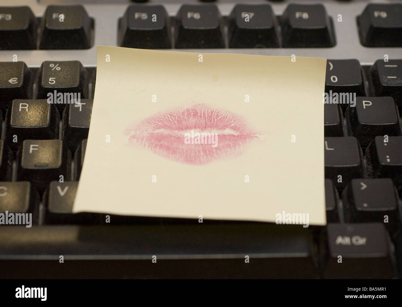 A post it note with a lipstick image of a womens lips, placed on a ...