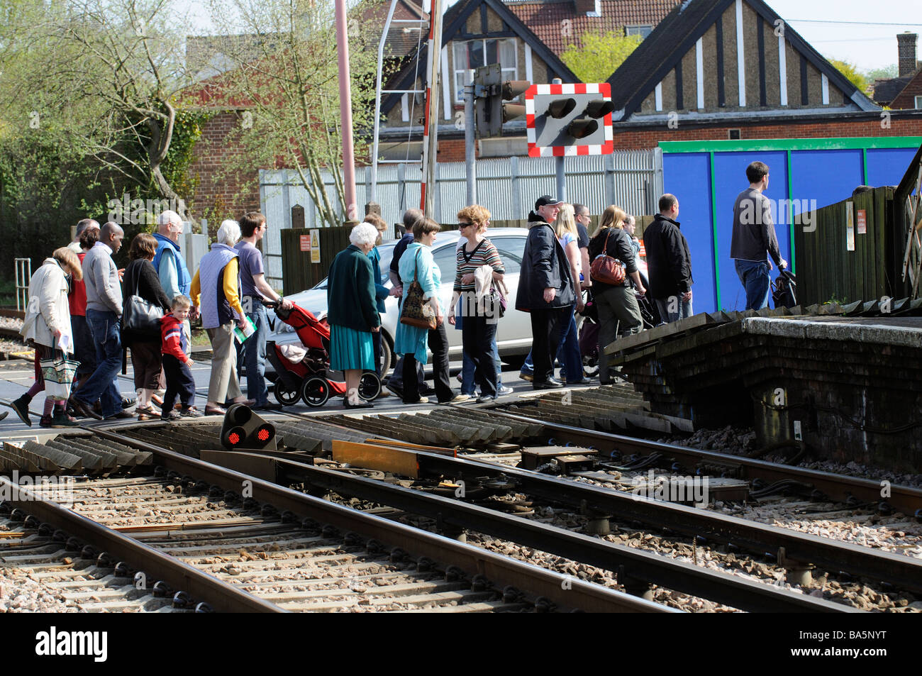 Pedestrians cross a unmanned level crossing at Petersfield railway ...