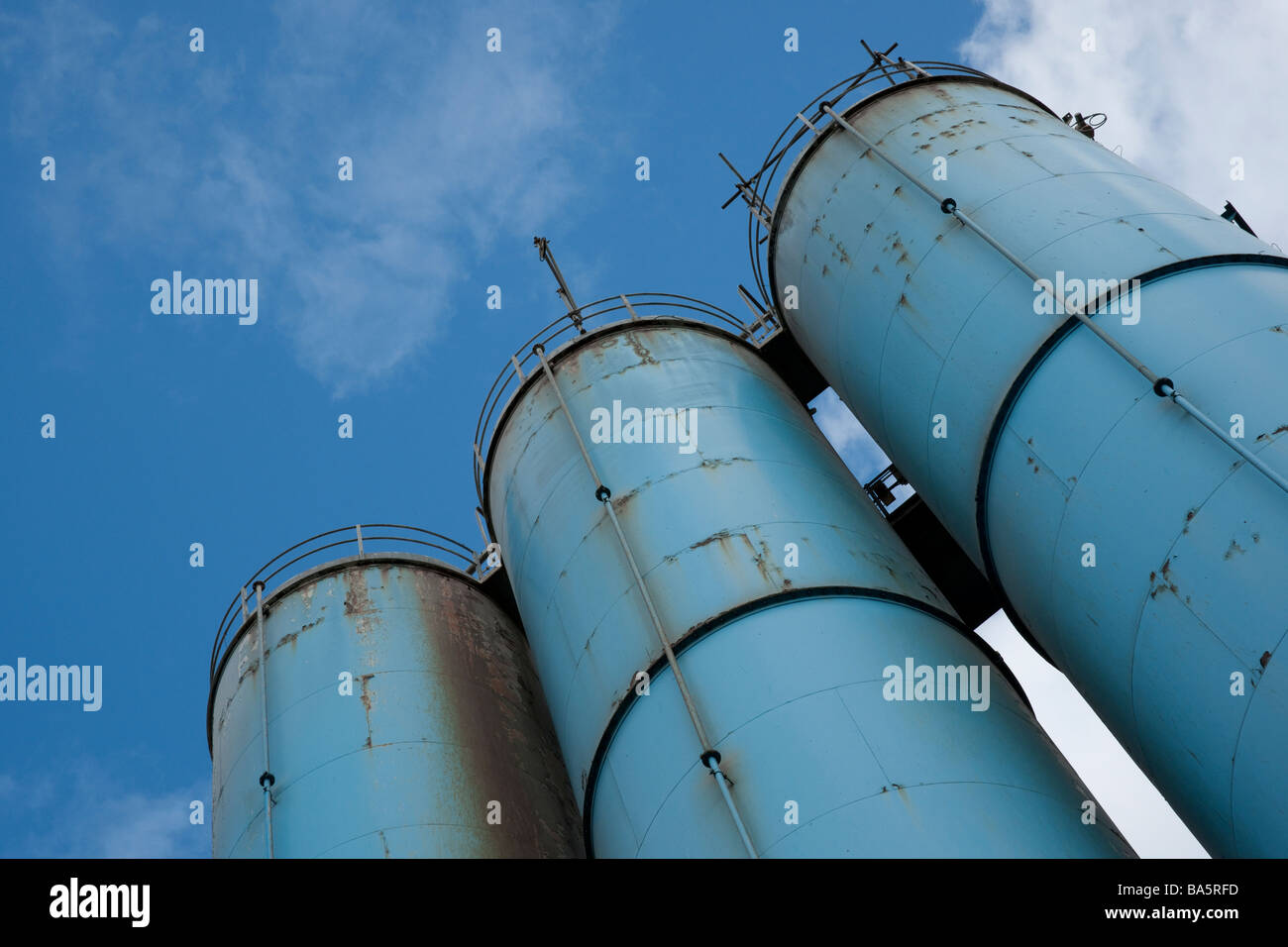 Three blue rusty silos against blue sky Stock Photo - Alamy