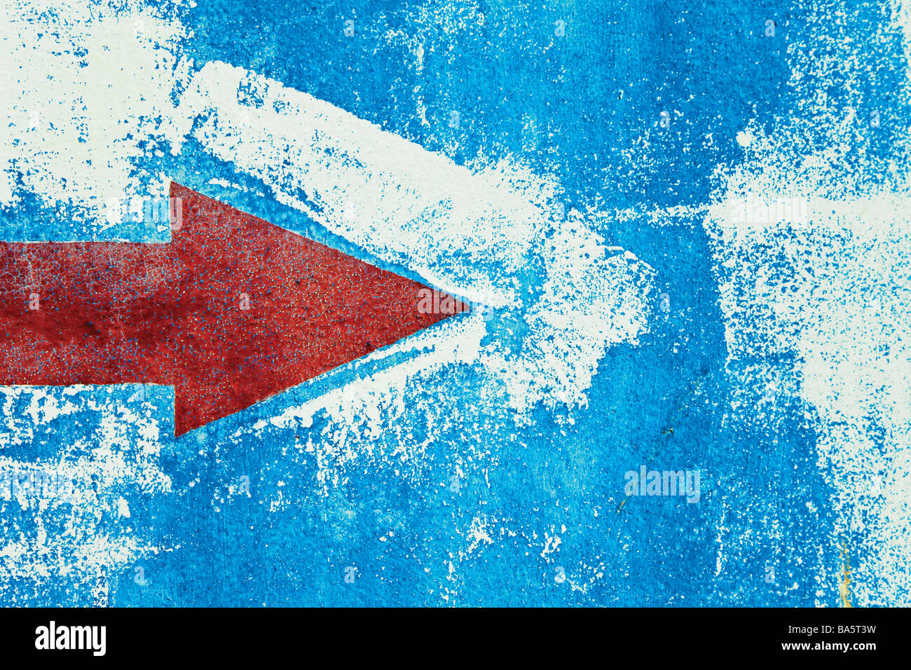 Red arrow painted on blue wall Stock Photo - Alamy