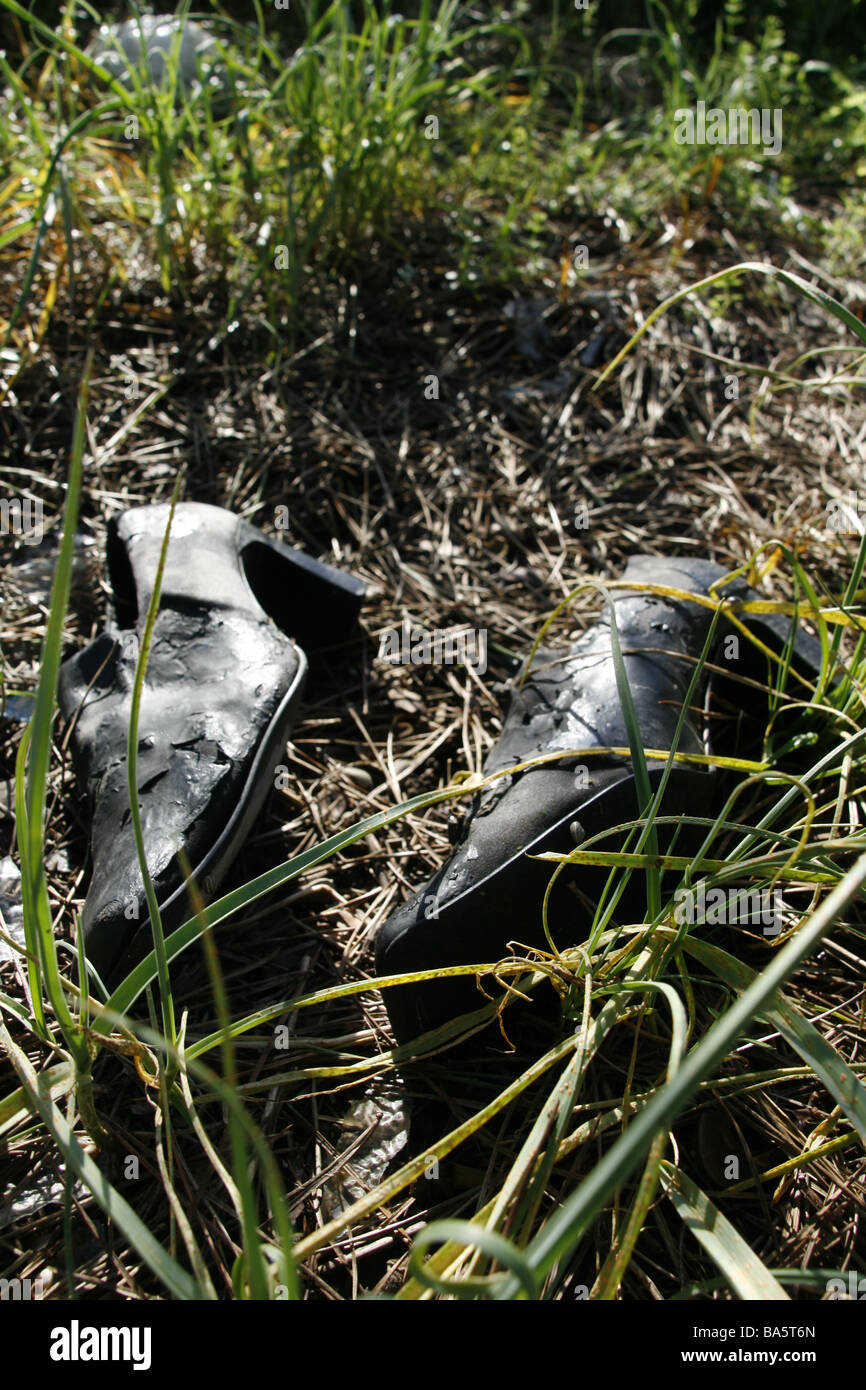 pair of old dirty woman's black shoes in rural derelict ground field in ...
