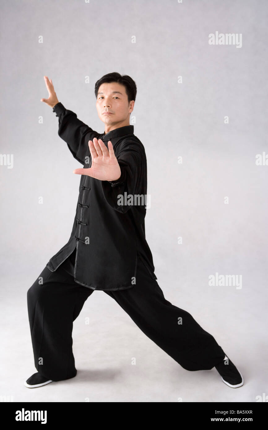 Man practicing Tai Chi against white background Stock Photo - Alamy