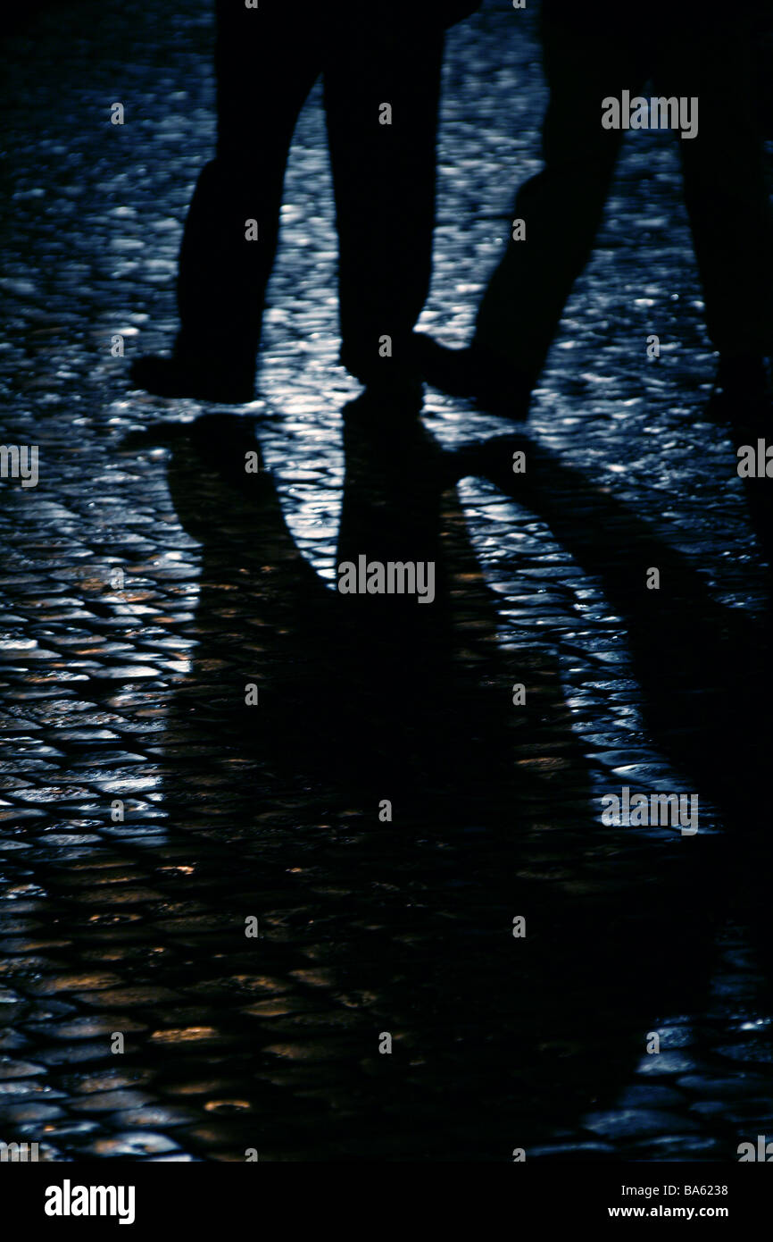 people walking on wet cobbled street at night Stock Photo - Alamy