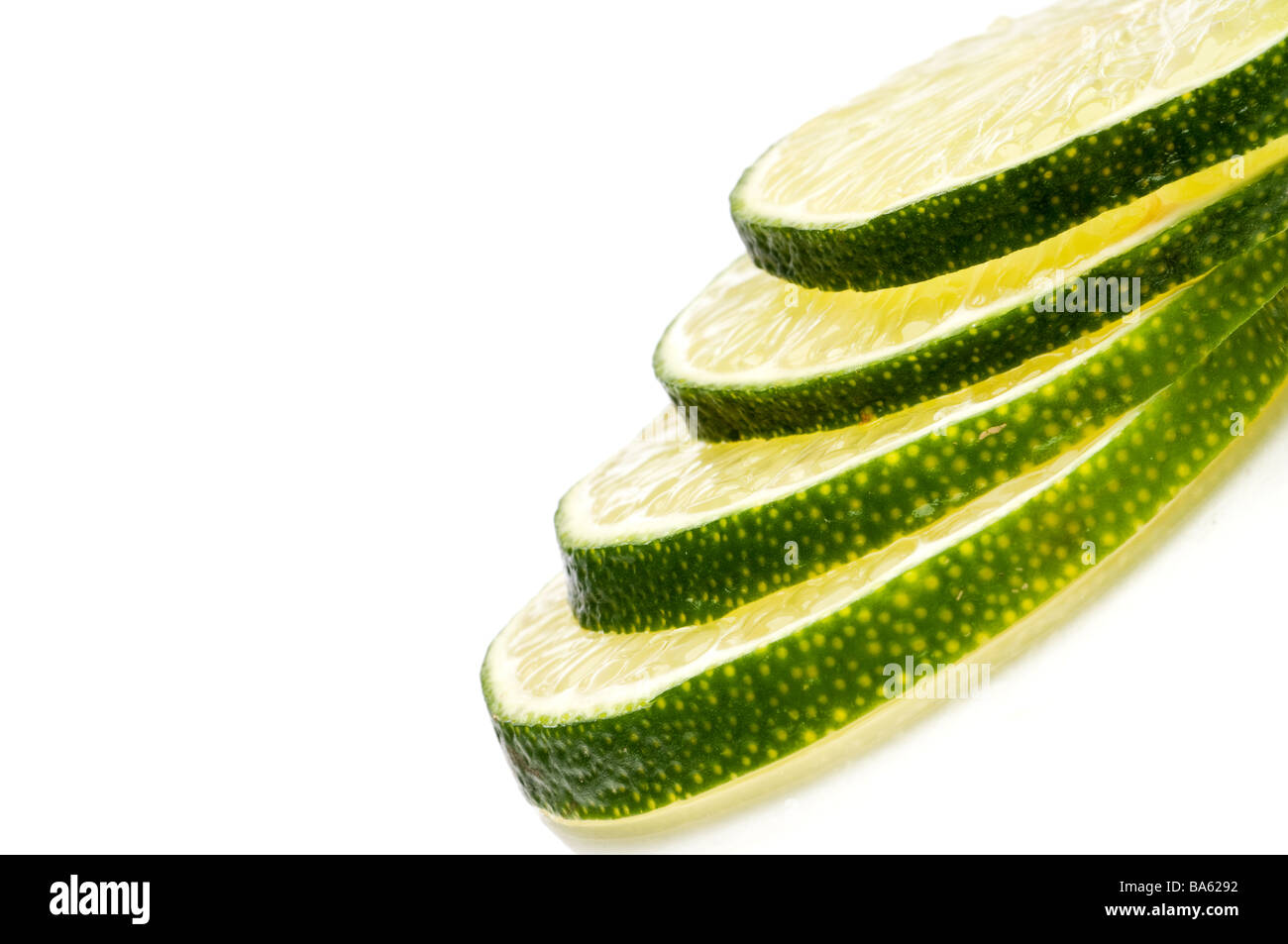 A tilted horizontal macro of a stack of juicy fresh cut lime slices ...
