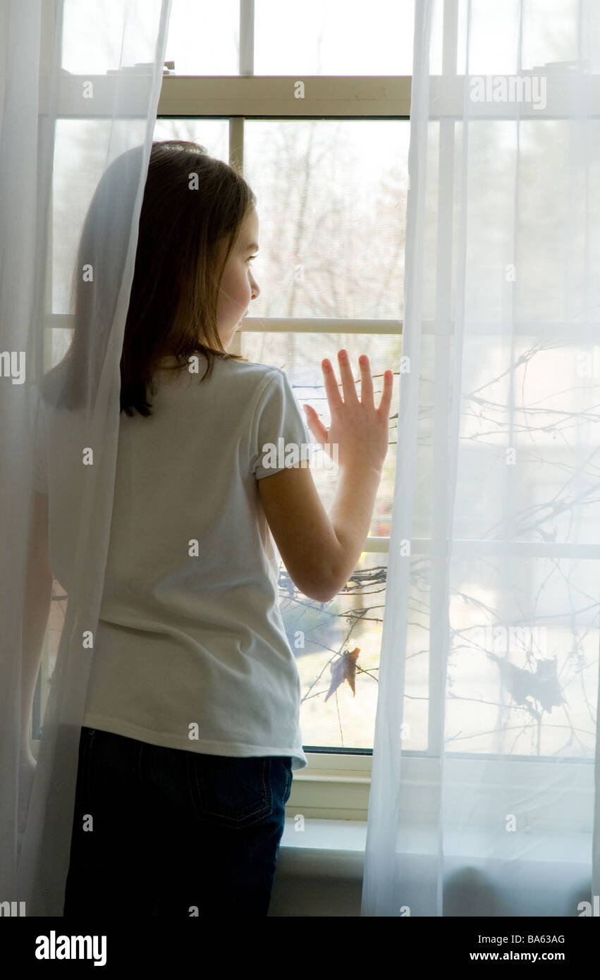 Young female looking out window Stock Photo - Alamy
