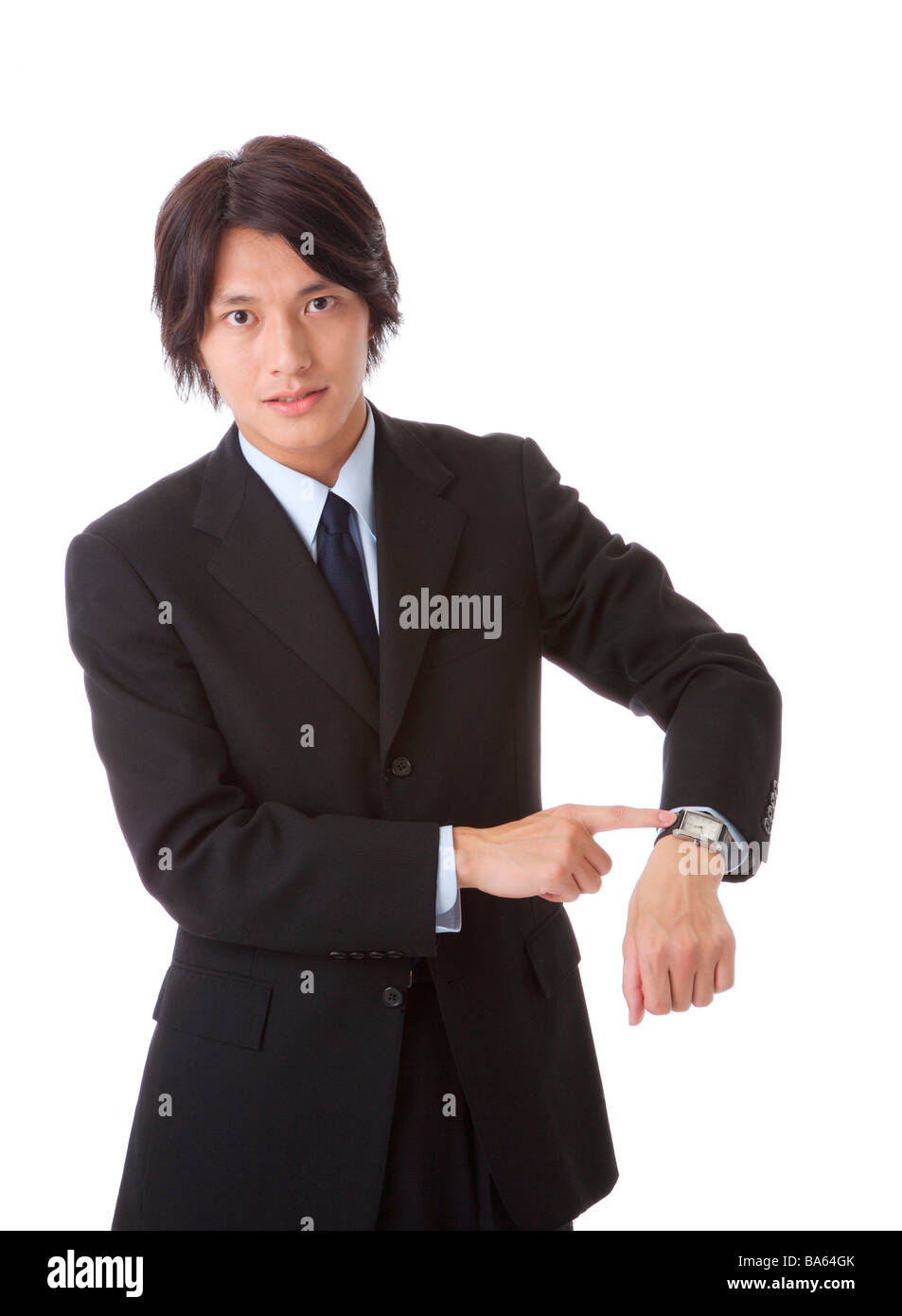 Businessman pointing at watch looking at camera Stock Photo - Alamy