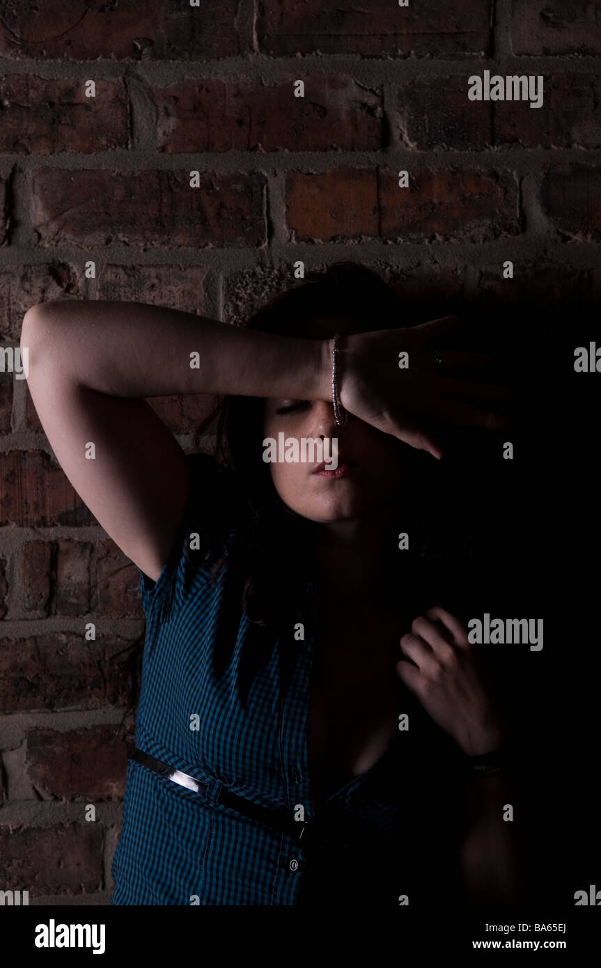 Woman hiding her face in fear in a dark alley Stock Photo - Alamy