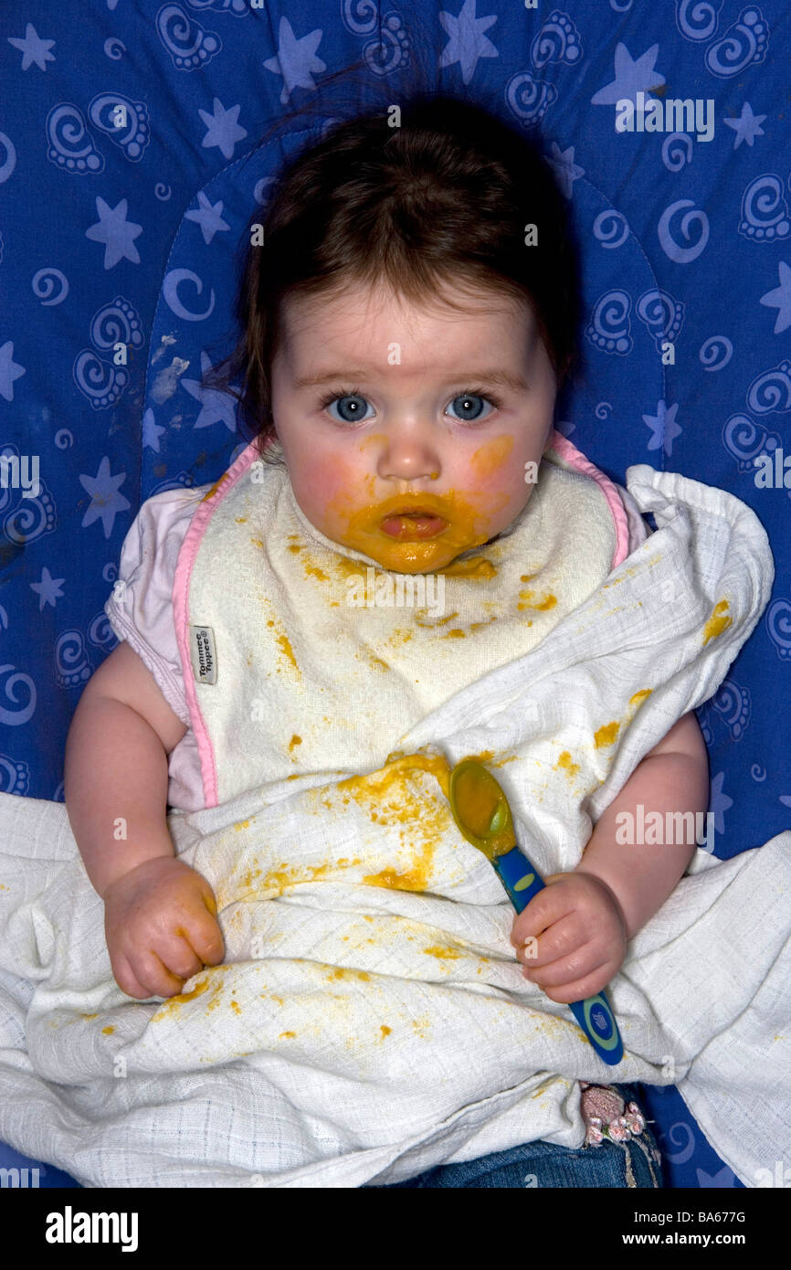 A messy looking baby girl eating food Stock Photo - Alamy