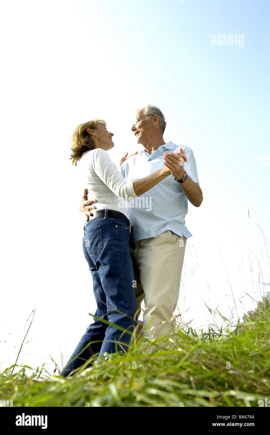 Meadow senior-pair laughs dances detail from below series people 50-60 ...