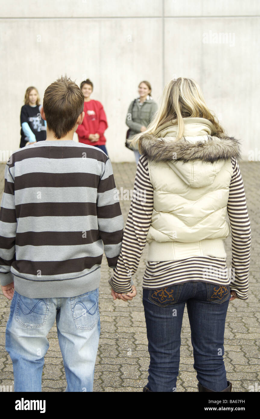 Teenager pair hand in hand back-opinion group falls in love laughs ...