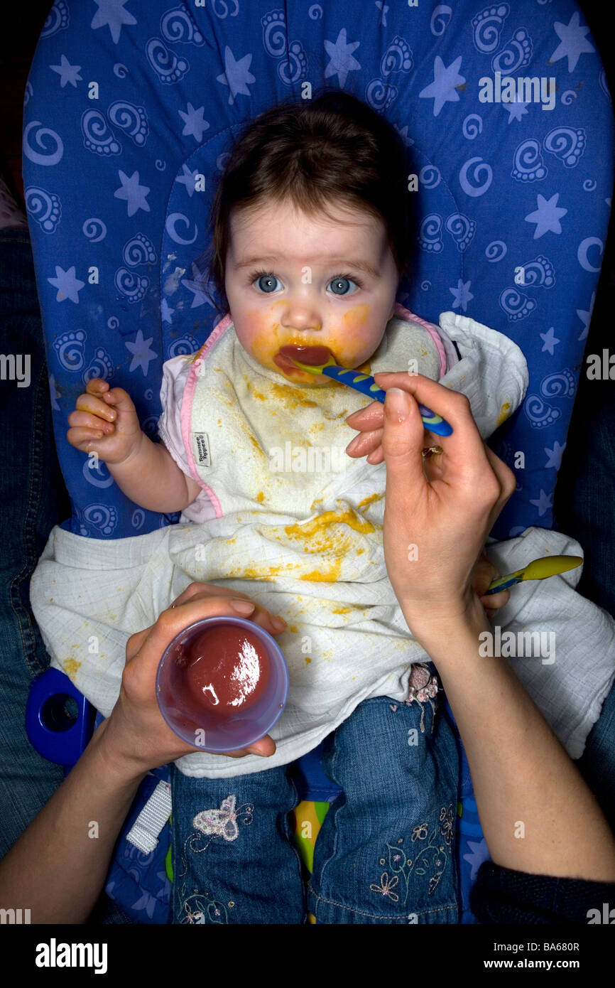 A messy looking baby girl eating food Stock Photo - Alamy