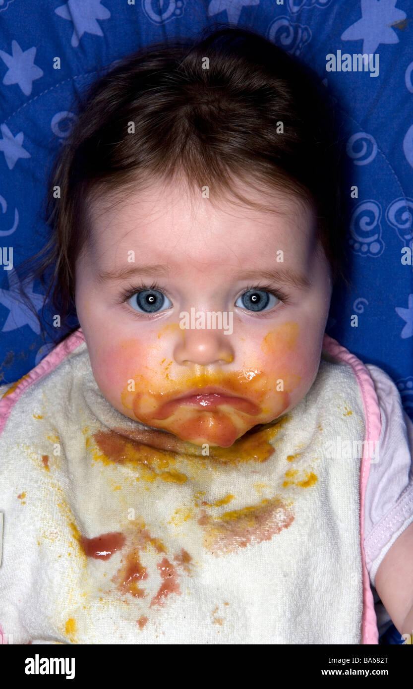 A messy looking baby girl eating food Stock Photo - Alamy