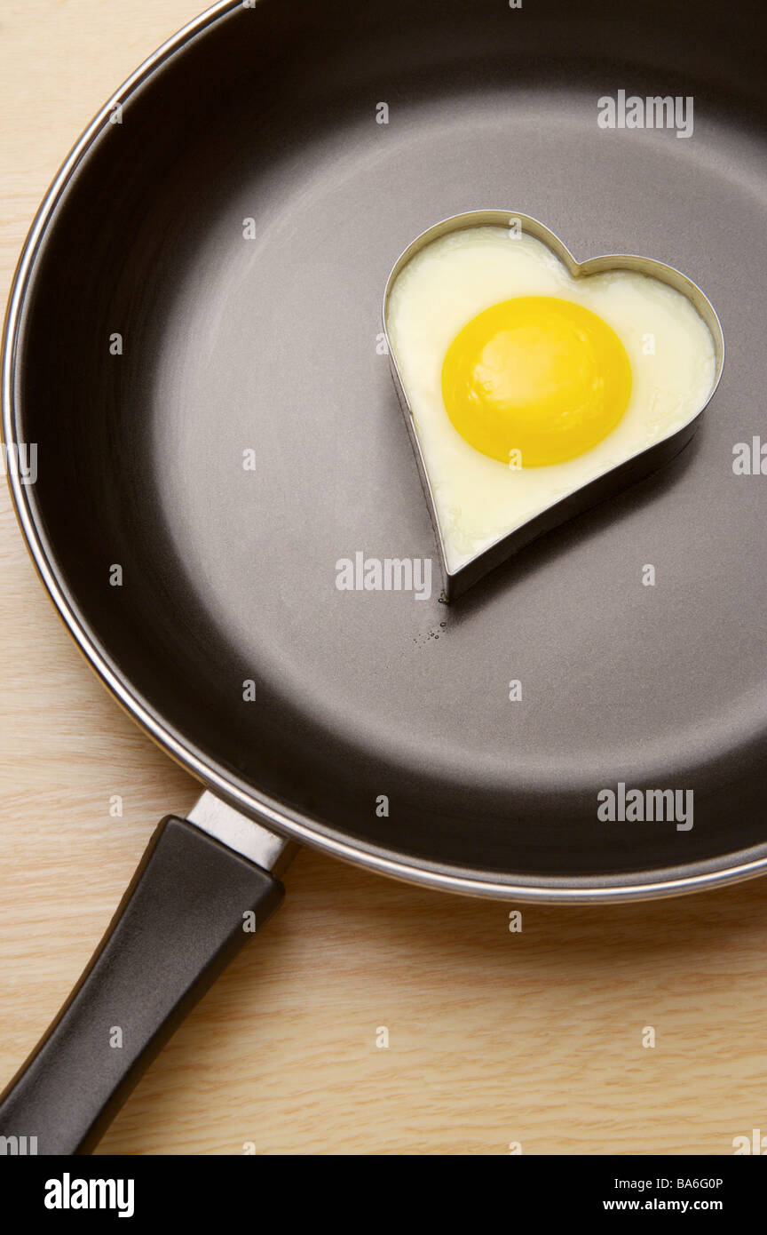 Heart shaped cracked egg in pan Stock Photo - Alamy