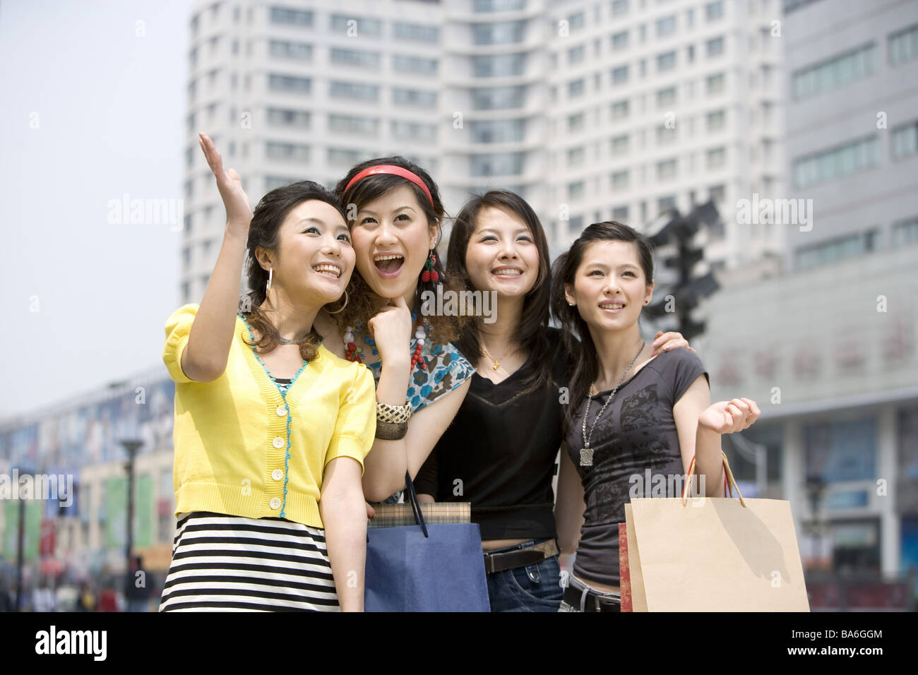 Four young women on city street smiling portrait Stock Photo - Alamy