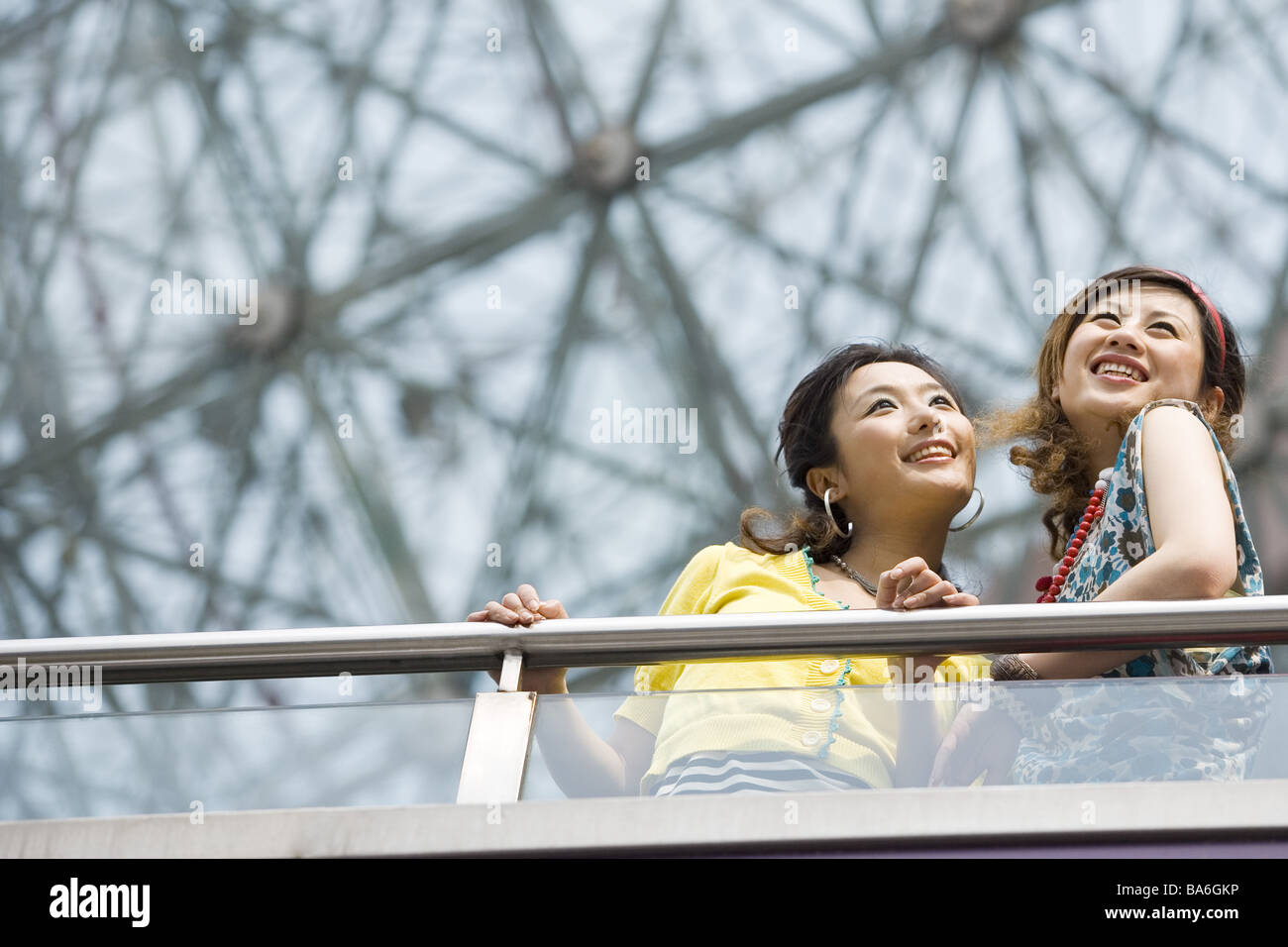 Three young women leaning on railing smiling portrait Stock Photo - Alamy