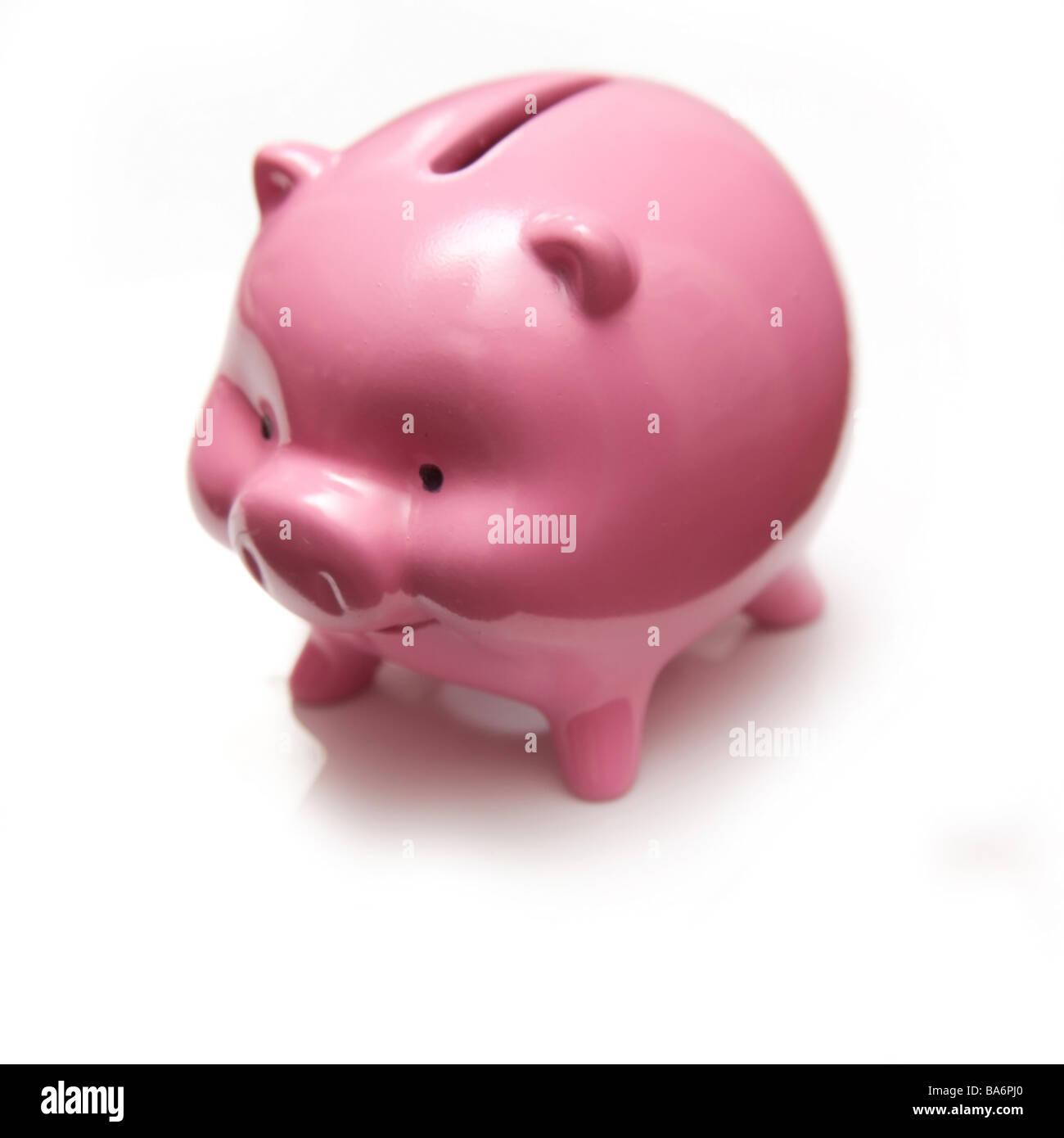 Pink piggy bank style money box isolated on a white studio background ...