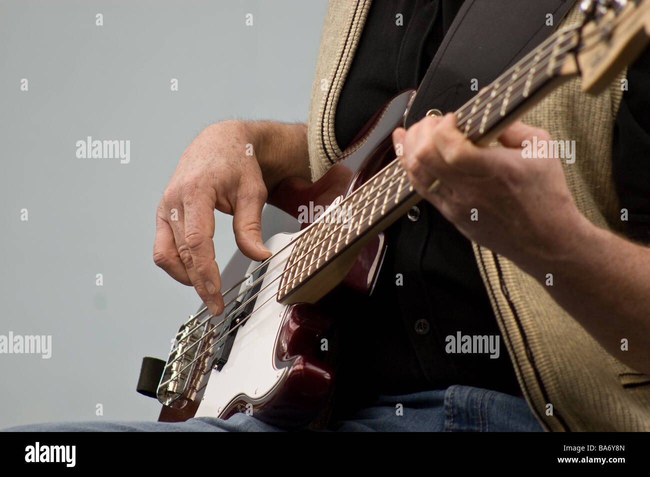 A man playing a bass guitar in a band Stock Photo - Alamy